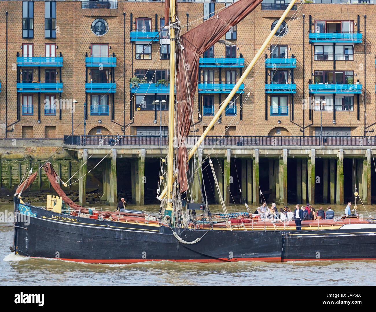 Sailboat passing luxury apartments on river Thames in east London ...