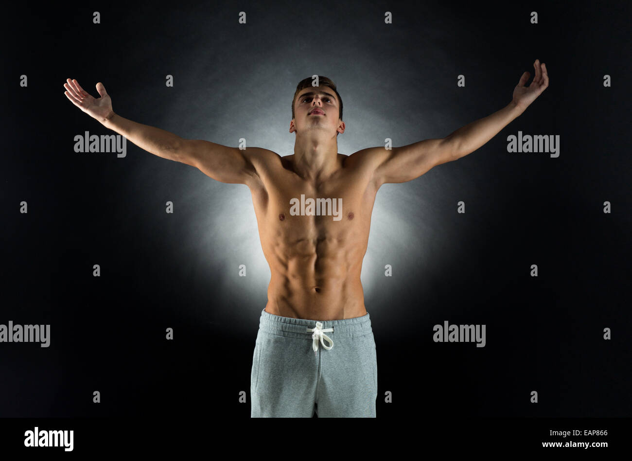 young male bodybuilder with raised hands Stock Photo - Alamy