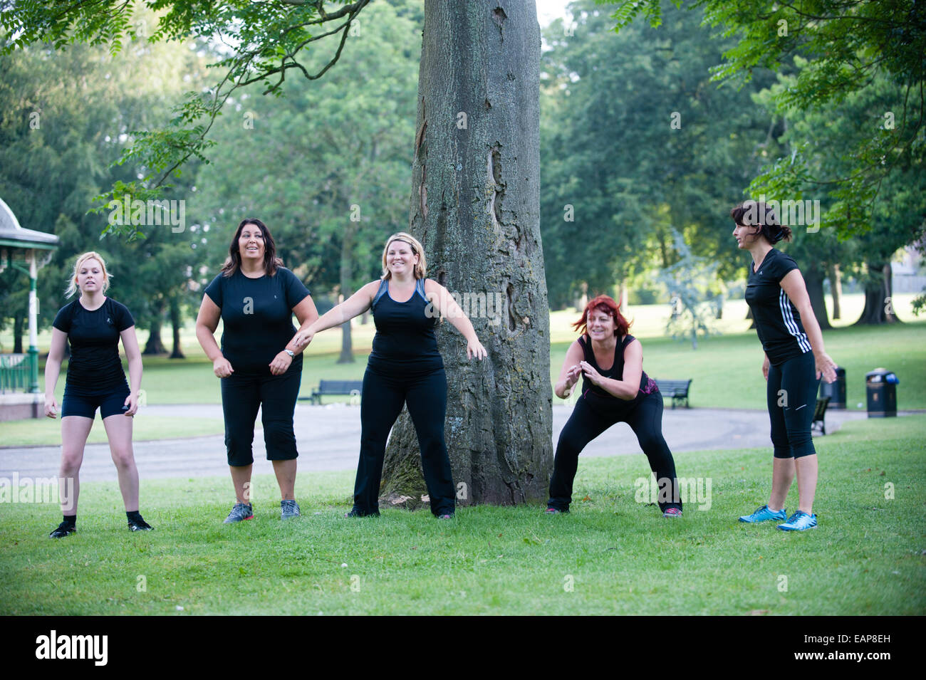 Five white overweight women in gym clothes having fun at a boot camp ...