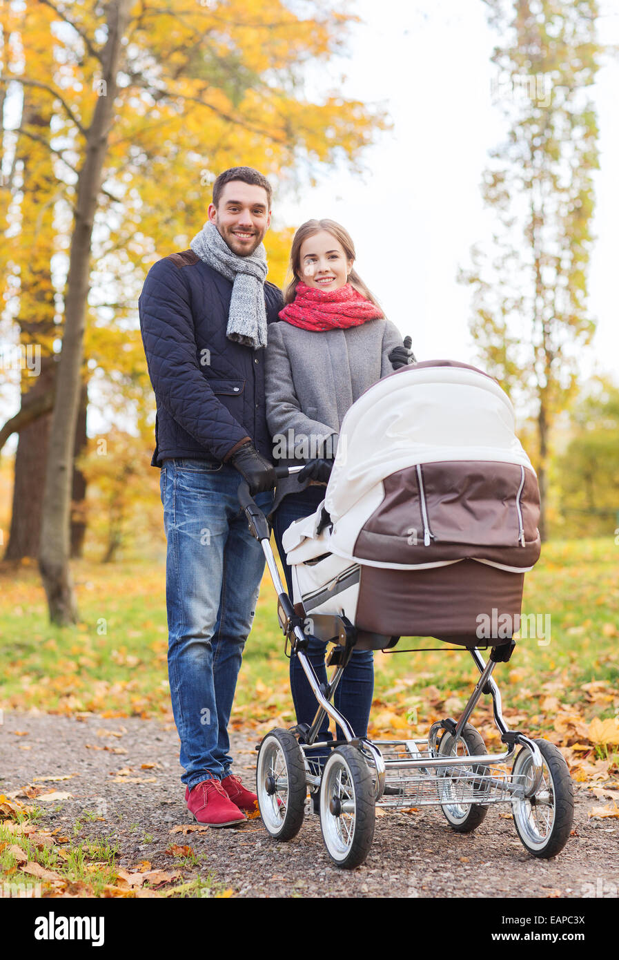 smiling couple with baby pram in autumn park Stock Photo - Alamy