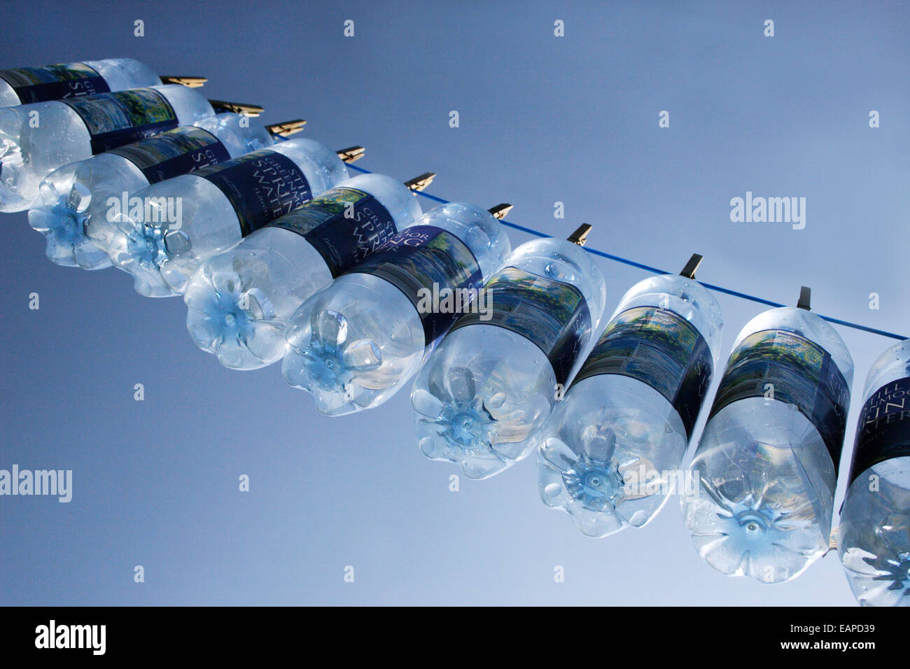 plastic spring water bottles hanging up on line Stock Photo - Alamy