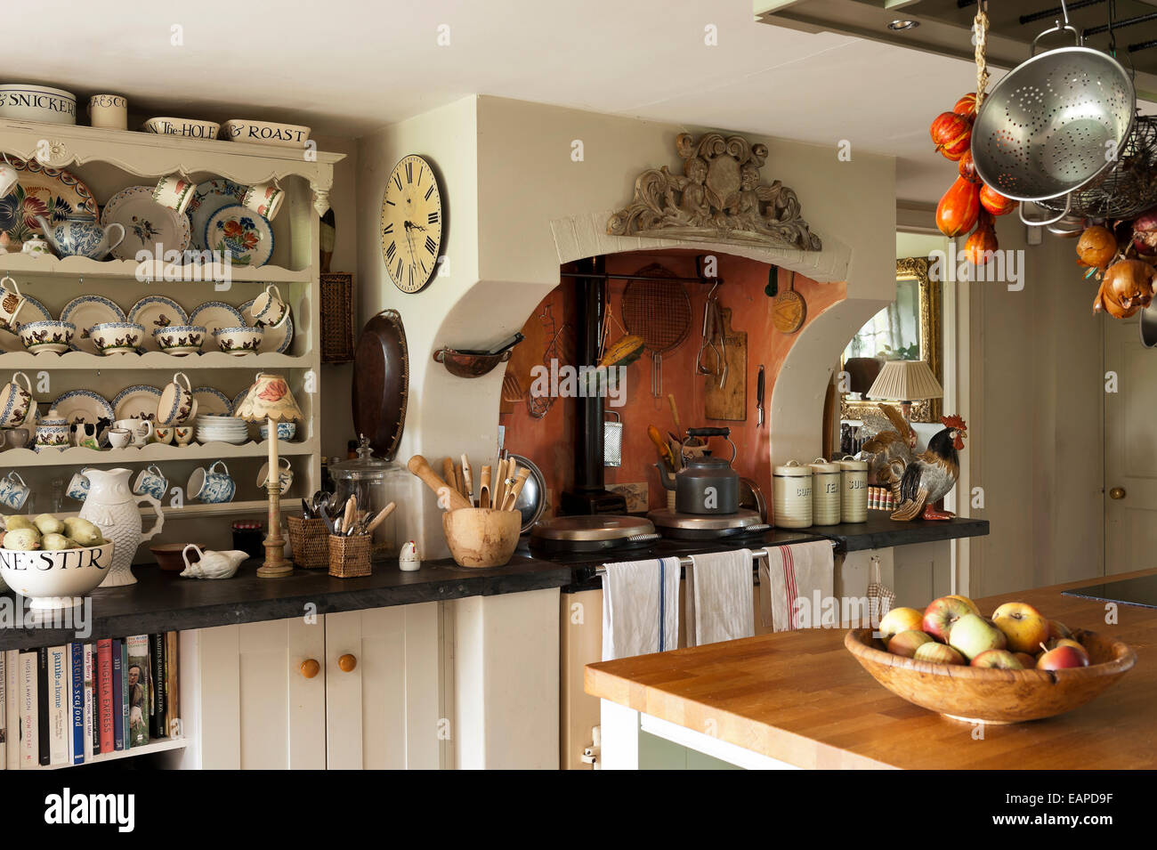 Assorted pottery on dresser in country kitchen with aga and butchers ...