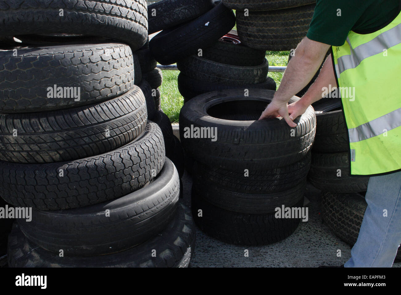 amenity tip & recycling, workman selecting tyres Stock Photo - Alamy