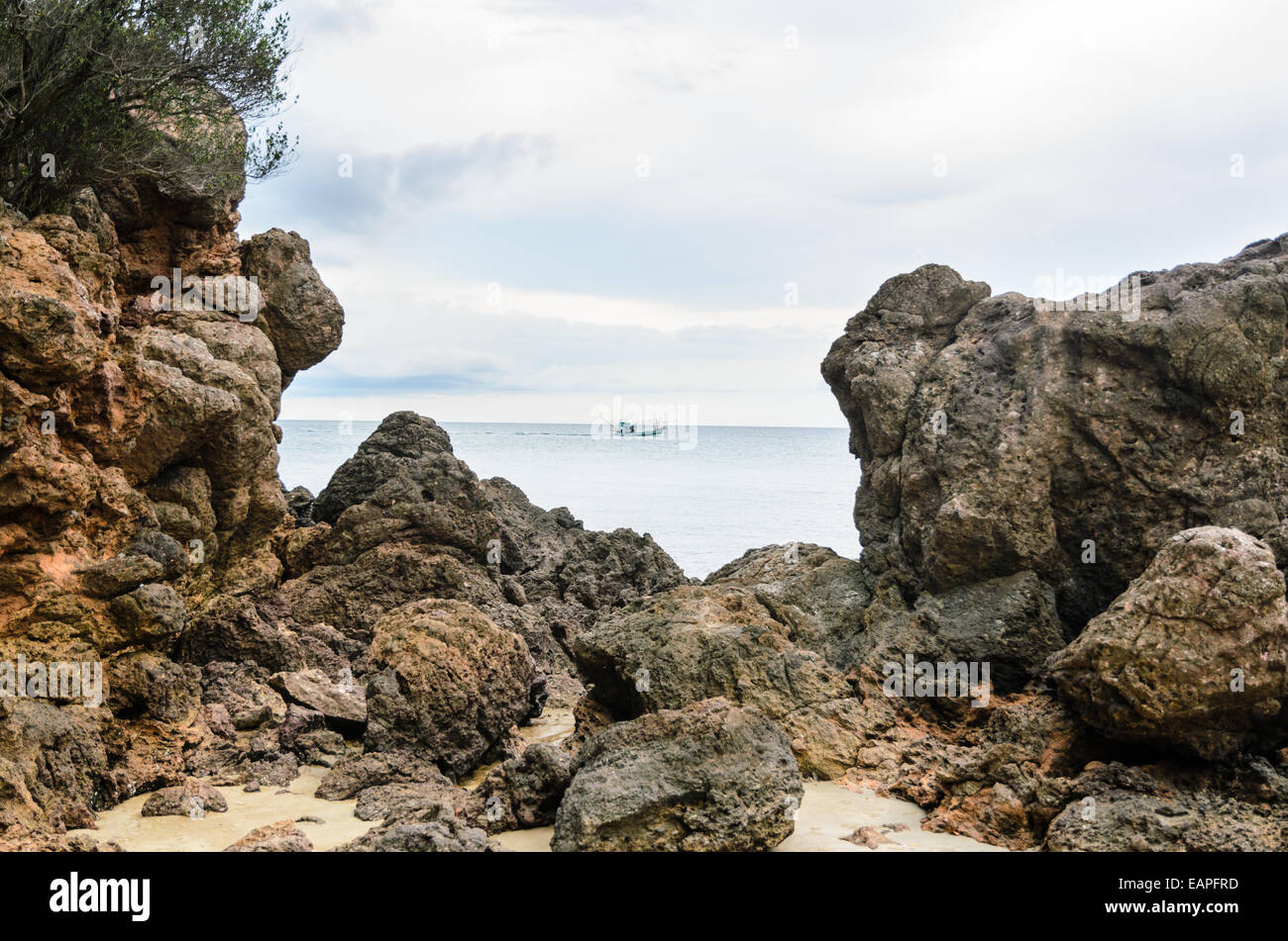 Sea View and fishing boat through the rocks on the island Stock Photo ...