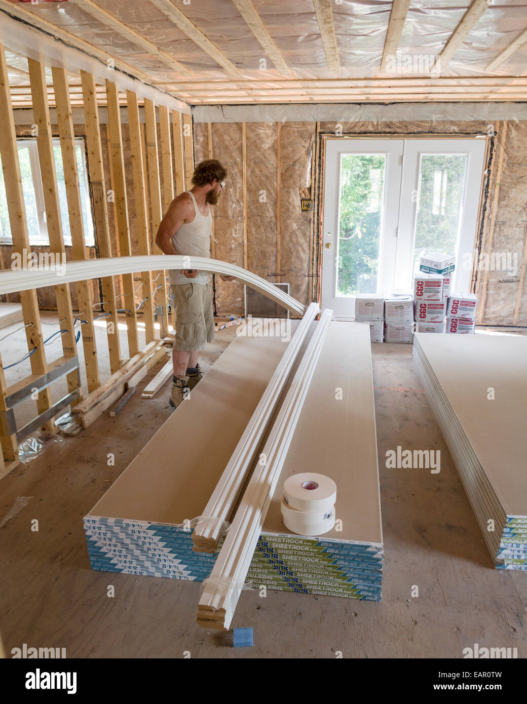 New House building, stacking trim. A worker stacks trim on top of ...