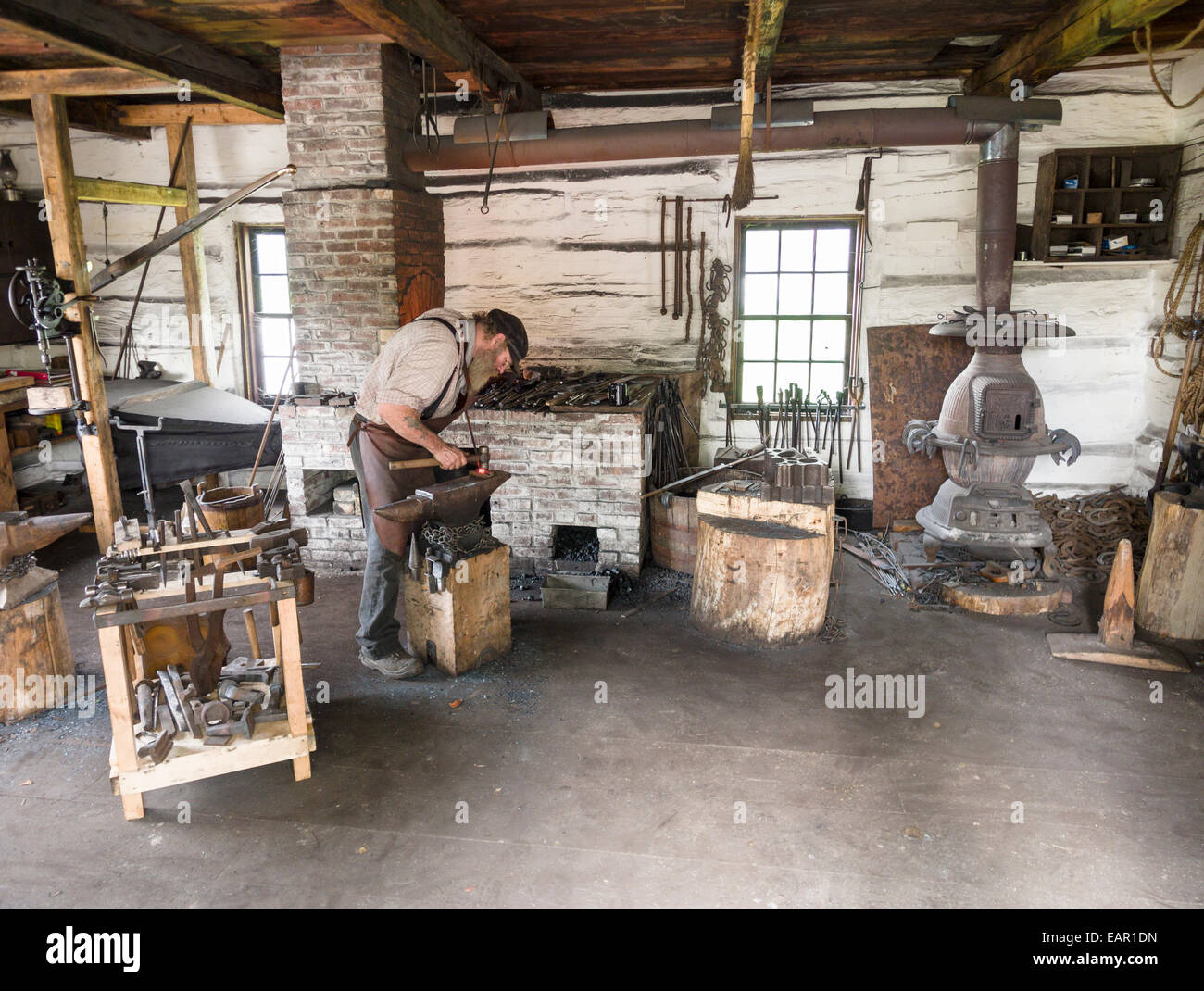 Blacksmith hammering. A Blacksmith hammers at a piece of iron on an ...