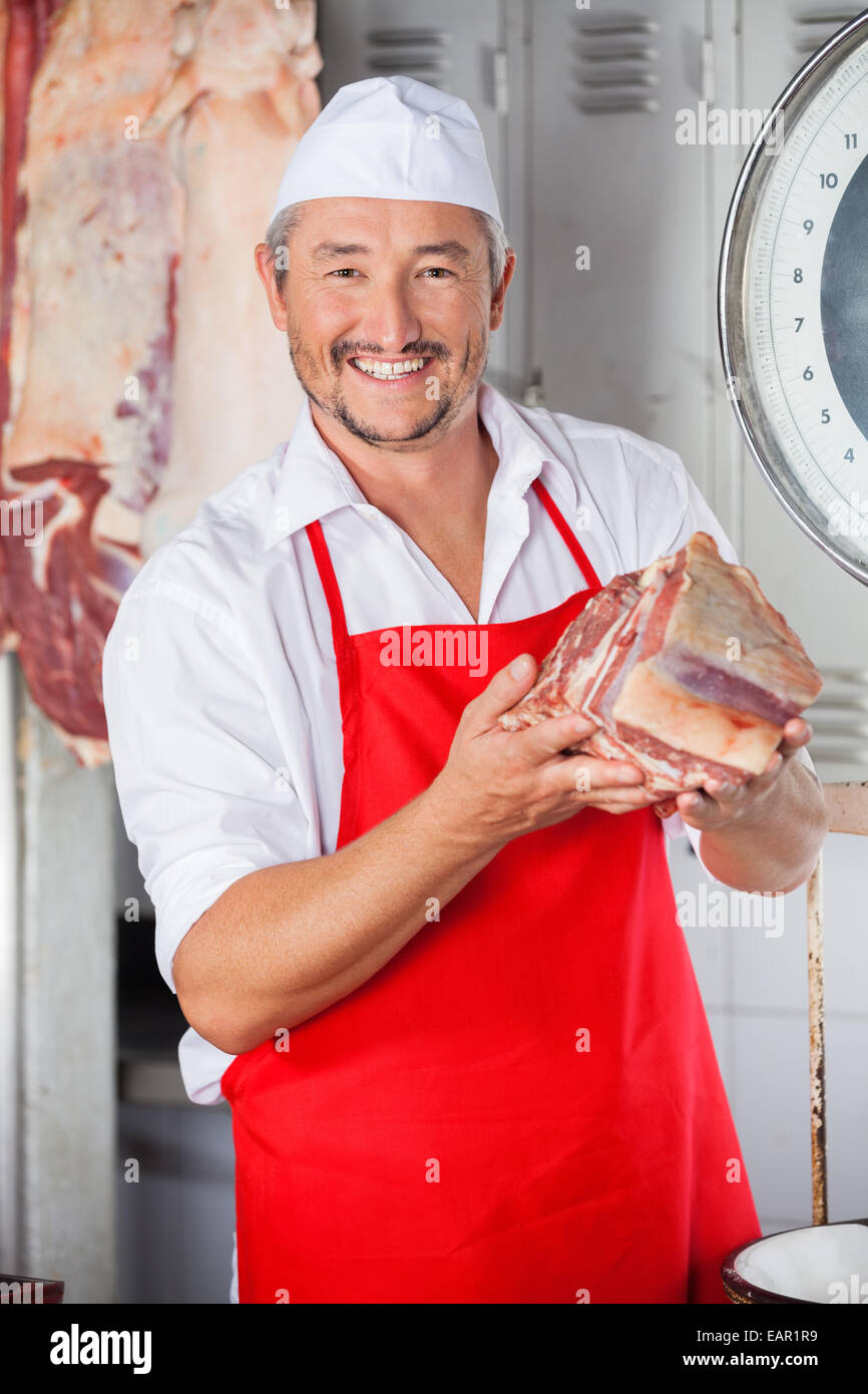 Confident Butcher Showing Meat Piece Stock Photo - Alamy