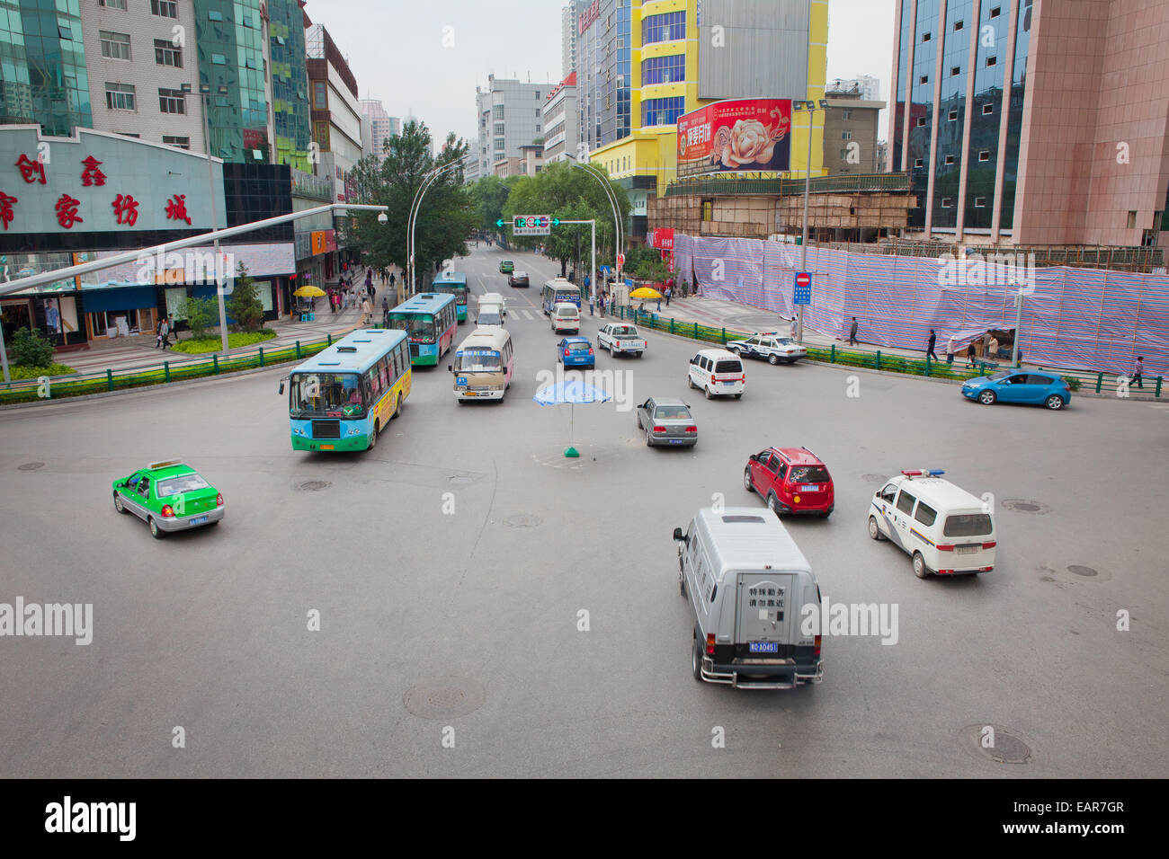 traffic on a street in Xining, buses, crossing, cars, umbrella, taxi ...