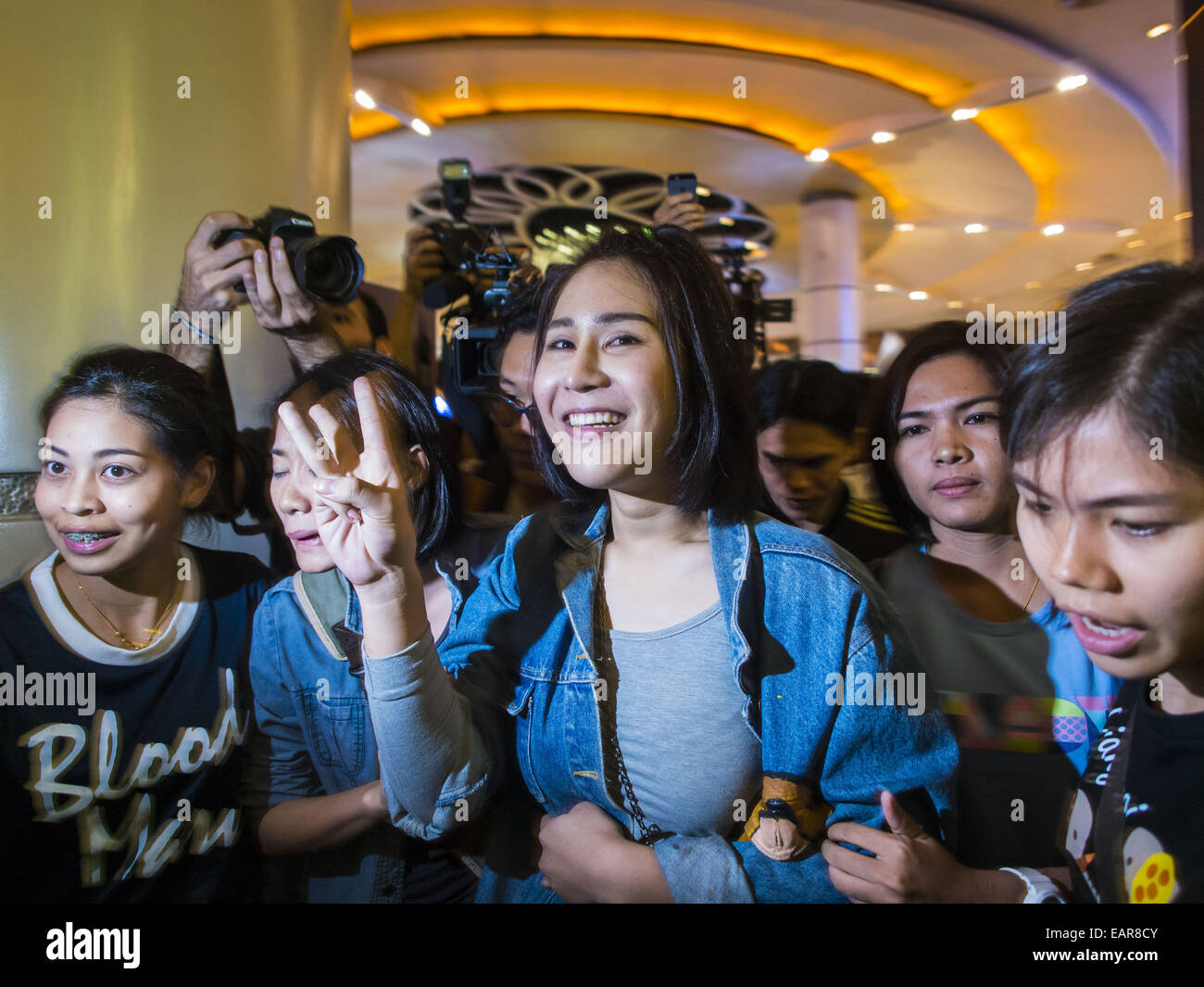 Bangkok, Thailand. 20th Nov, 2014. Plainclothes female Thai police officers lead NATCHACAH KONG ...