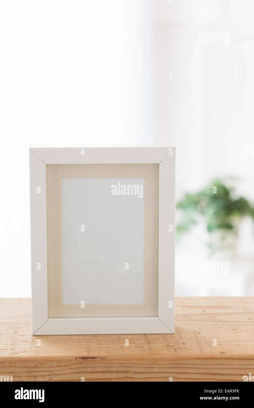 Empty photo frame on wooden table Stock Photo - Alamy