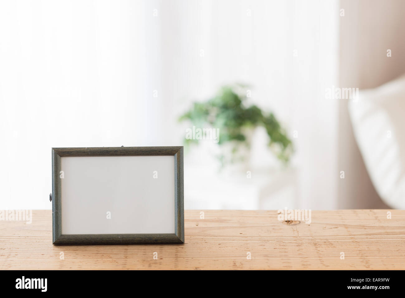 Empty photo frame on wooden table Stock Photo - Alamy