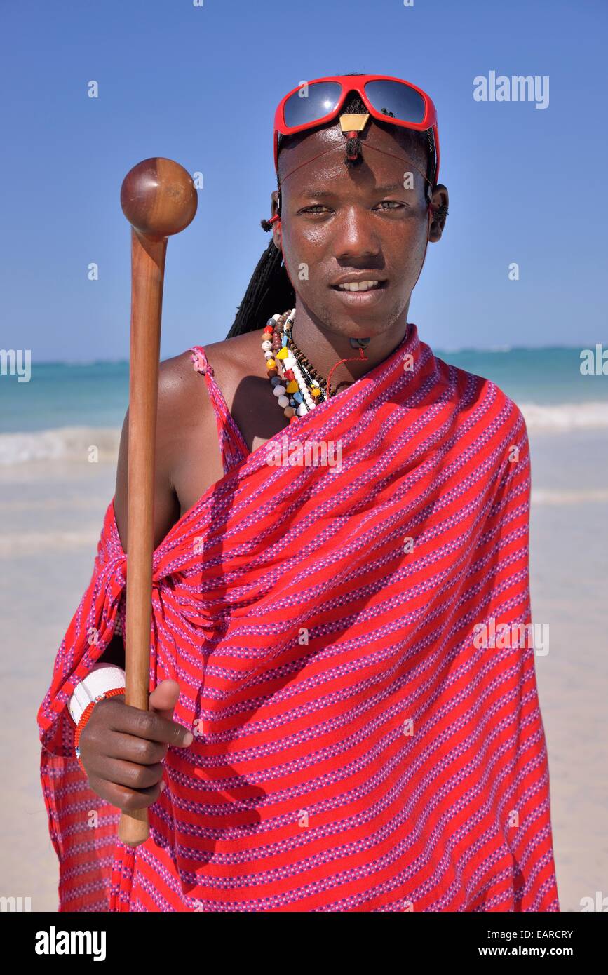 Young Maasai man wearing traditional dress and sunglasses on the beach ...