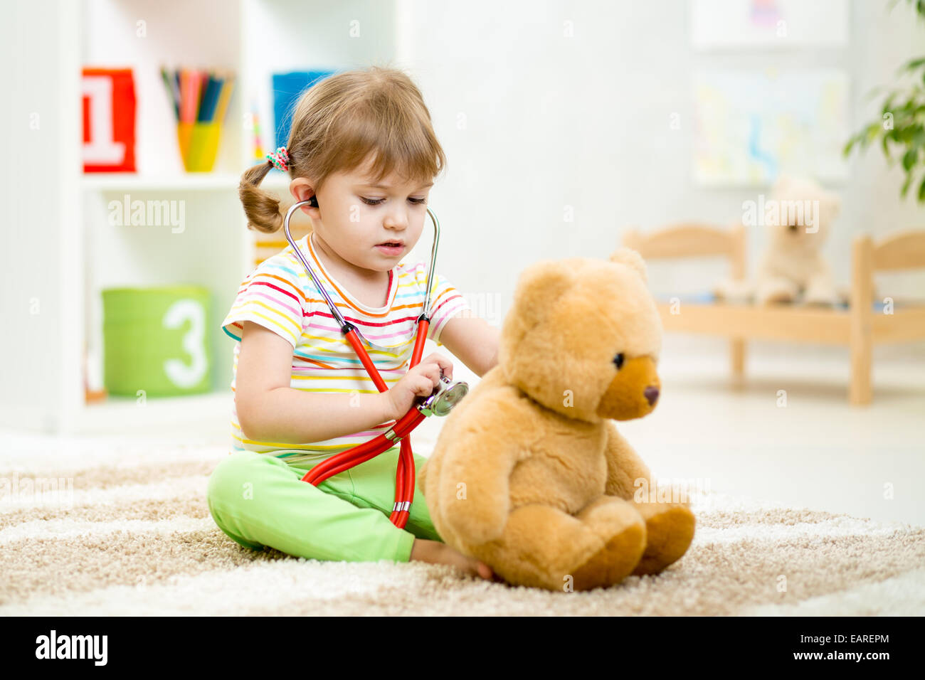 kid girl playing doctor with plush toy at home Stock Photo - Alamy