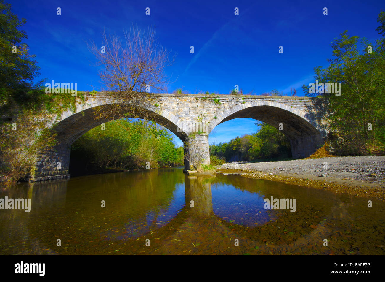 Abandoned stone bridge over a small river Stock Photo - Alamy