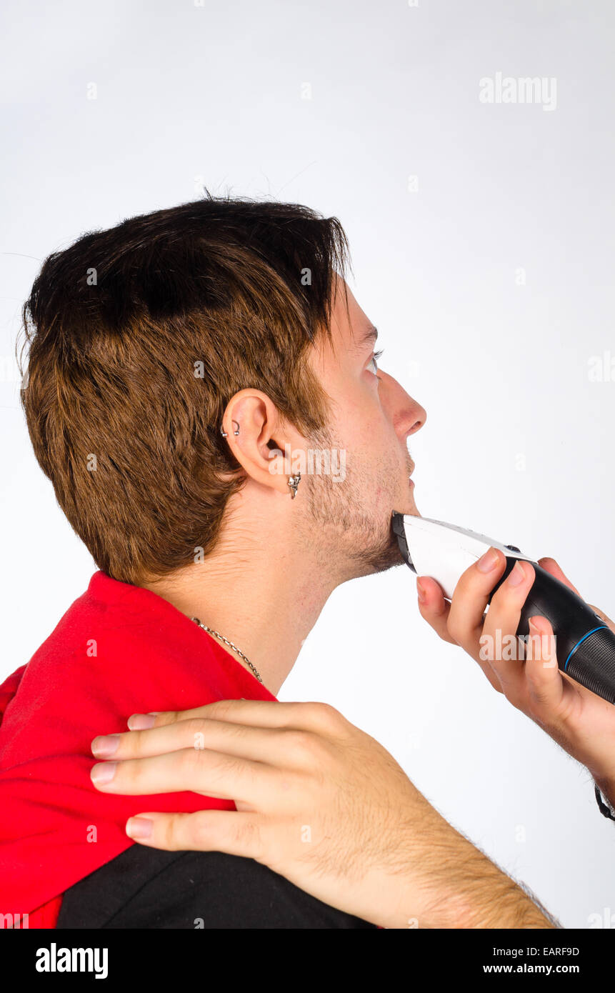 Barber trimming a beard with an electric razor Stock Photo - Alamy