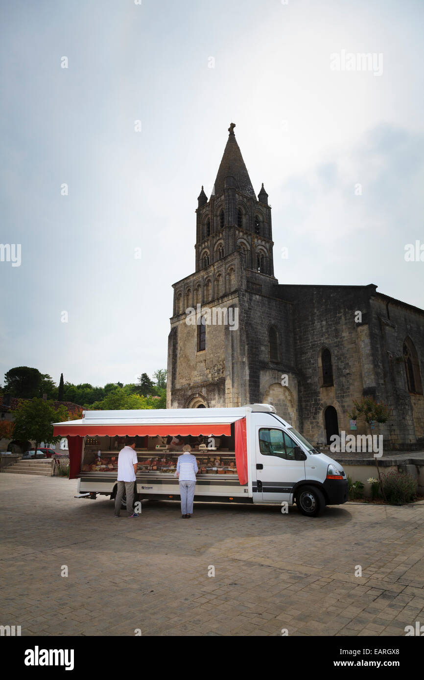 Mobile Butcher van visiting a french village square outside the church ...