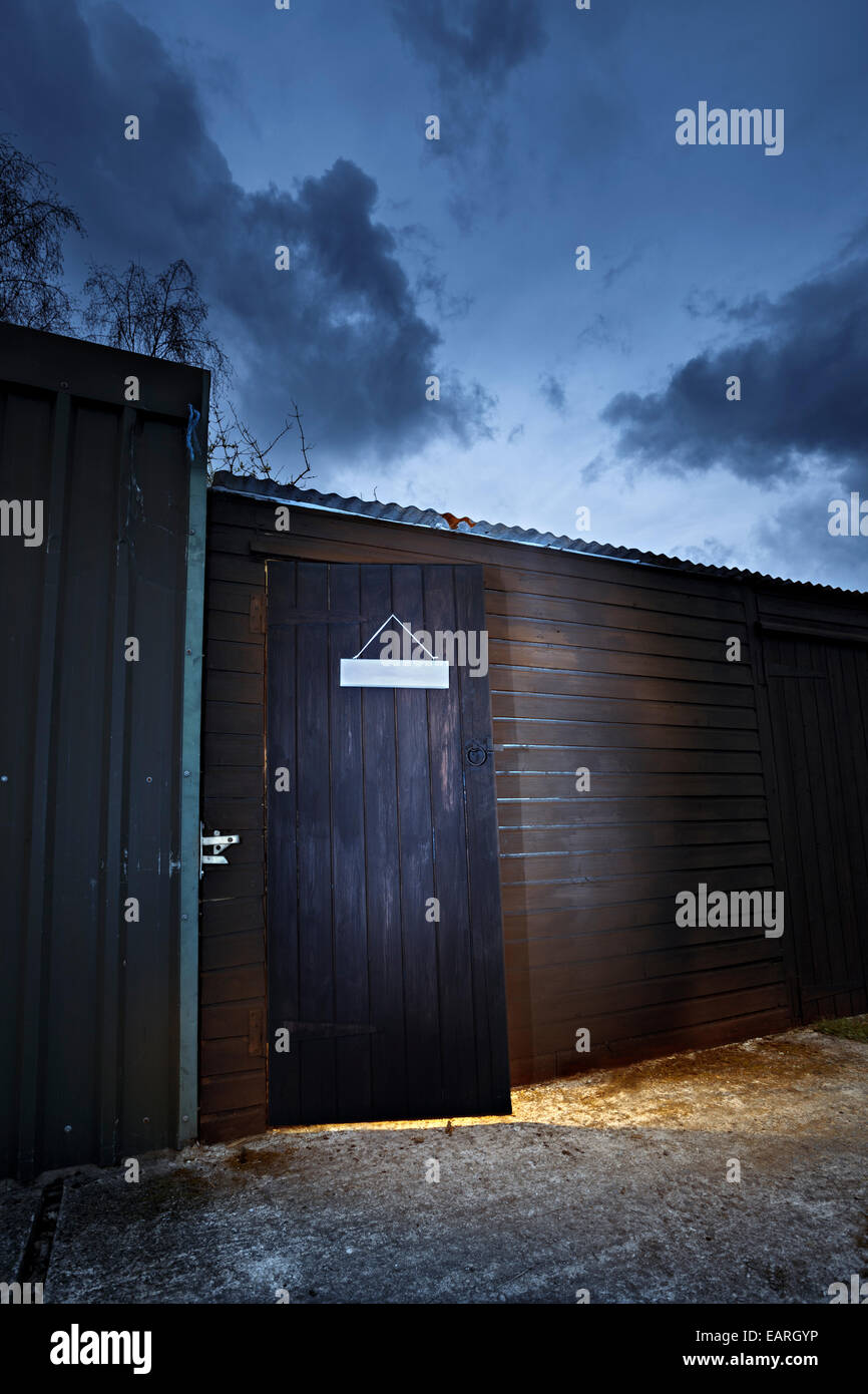 Light spilling from an open workshop door Stock Photo - Alamy