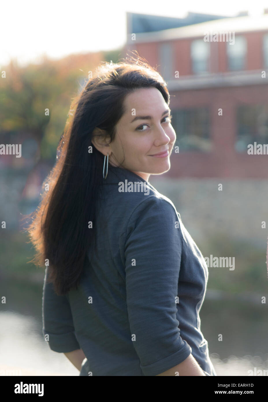 Woman in a city location with the sun behind her Stock Photo - Alamy