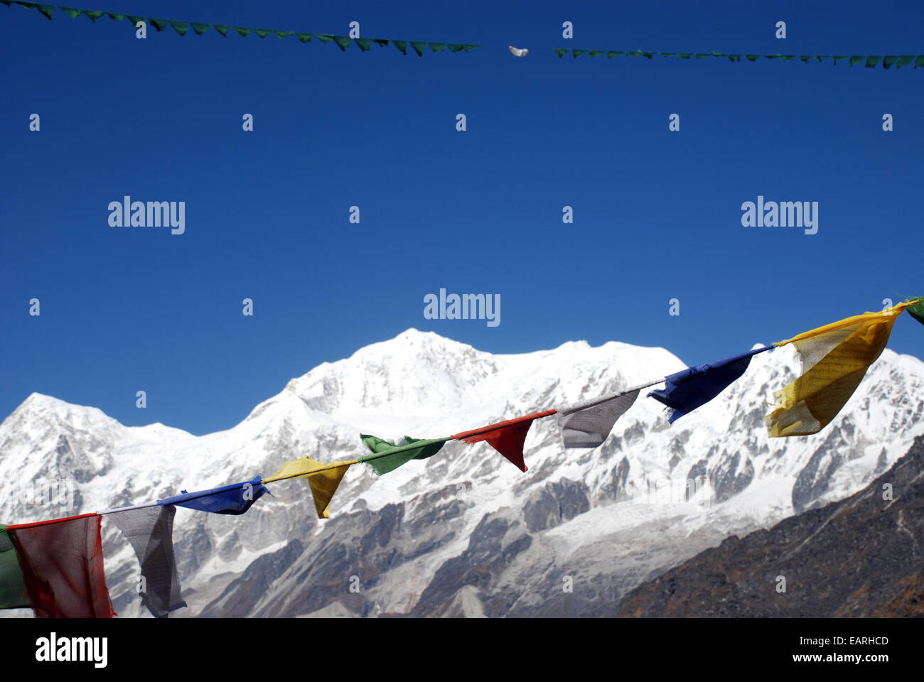 snowcapped Himalayan peaks are framed by Buddhist prayer flags in the ...
