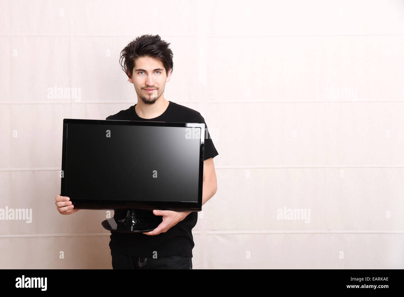 Young man holding a monitor Stock Photo - Alamy