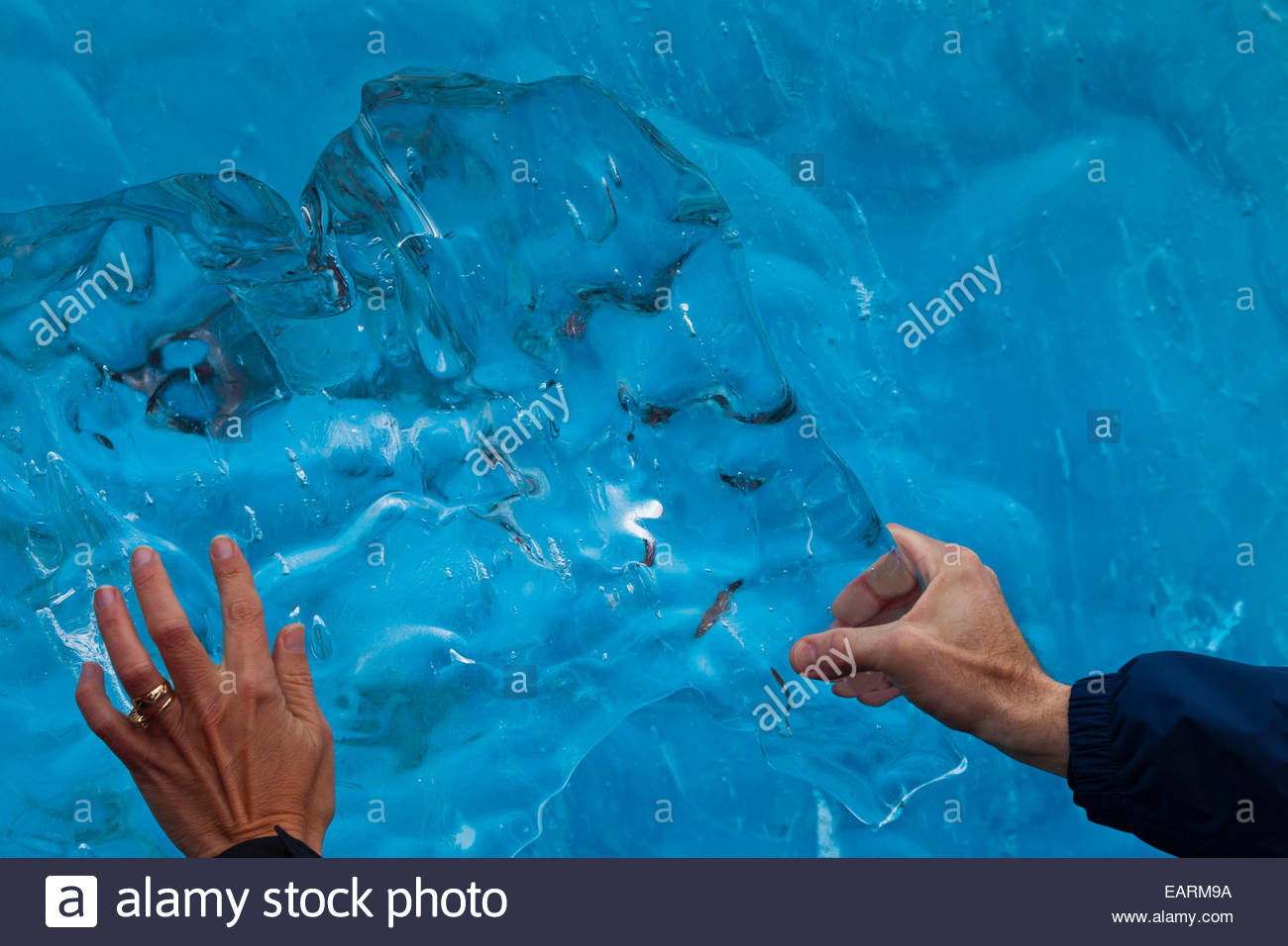 Hands grasp part of an iceberg Stock Photo - Alamy