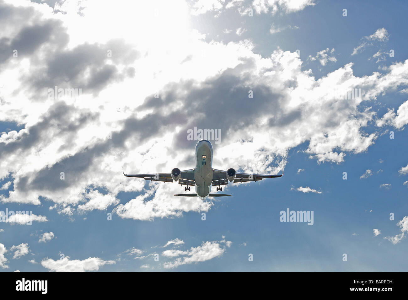 Jet Airplane Flying through Clouds Stock Photo - Alamy