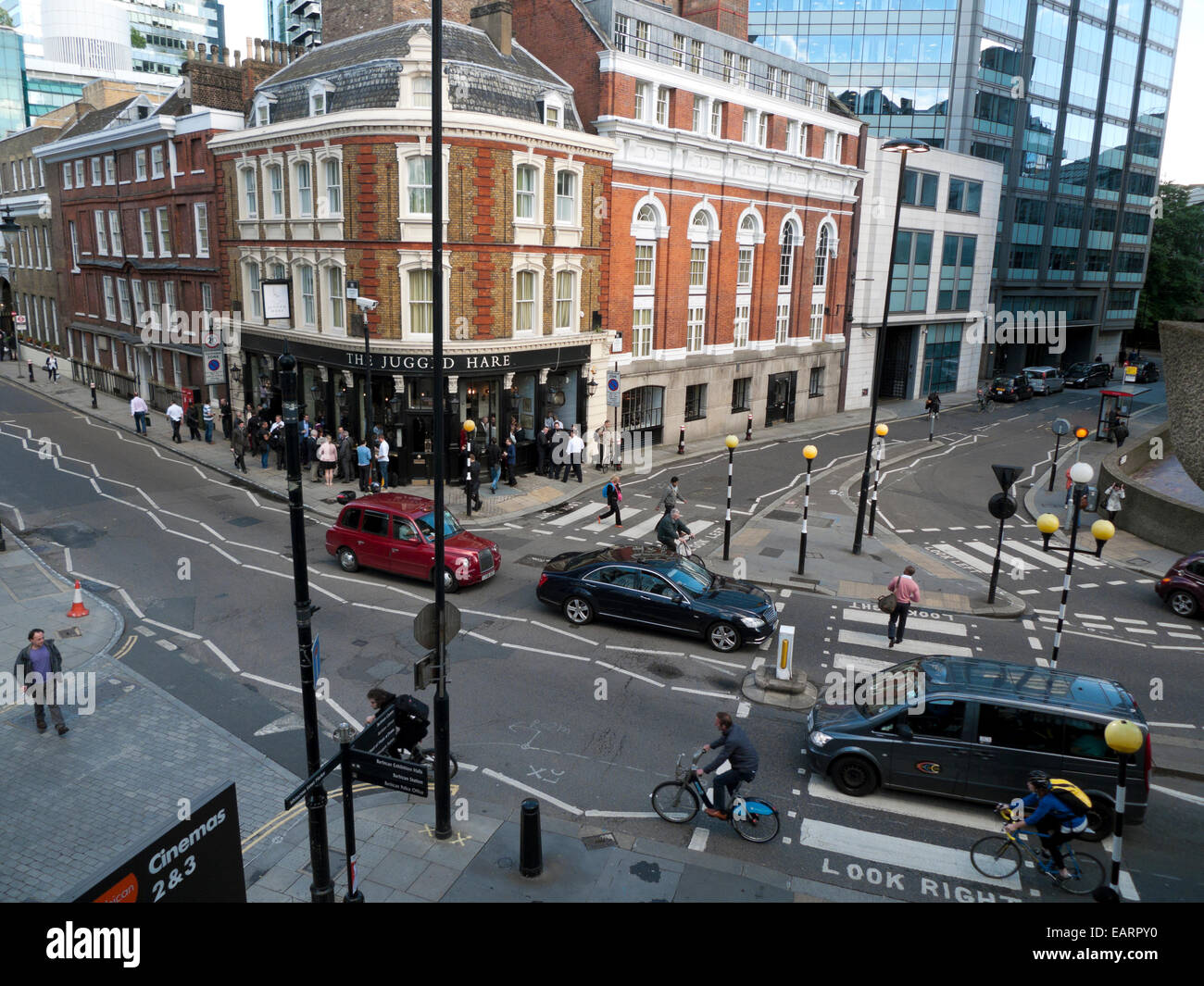 Cars and cyclists at busy intersection & crosswalk near the Barbican ...