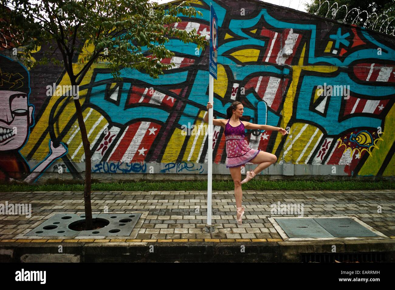 A dancer performs a ballet pose outdoors next to a urban grafitti Stock ...