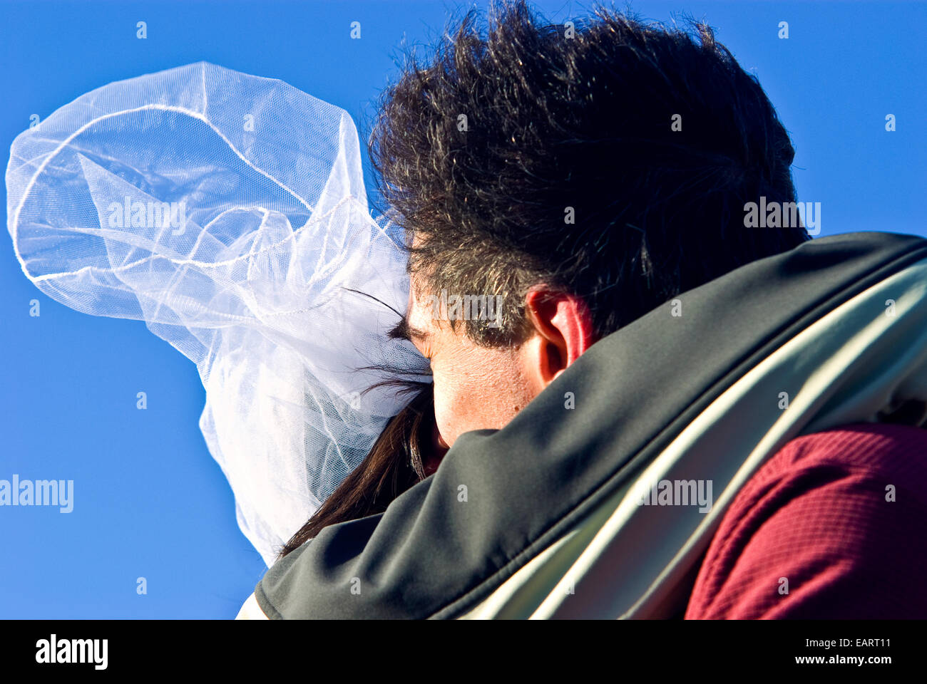 A groom kisses the bride during their windy wedding in Antarctica Stock ...