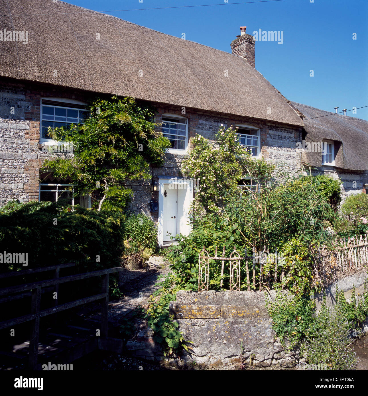 The exterior of a traditional country house with thatched roof and a ...