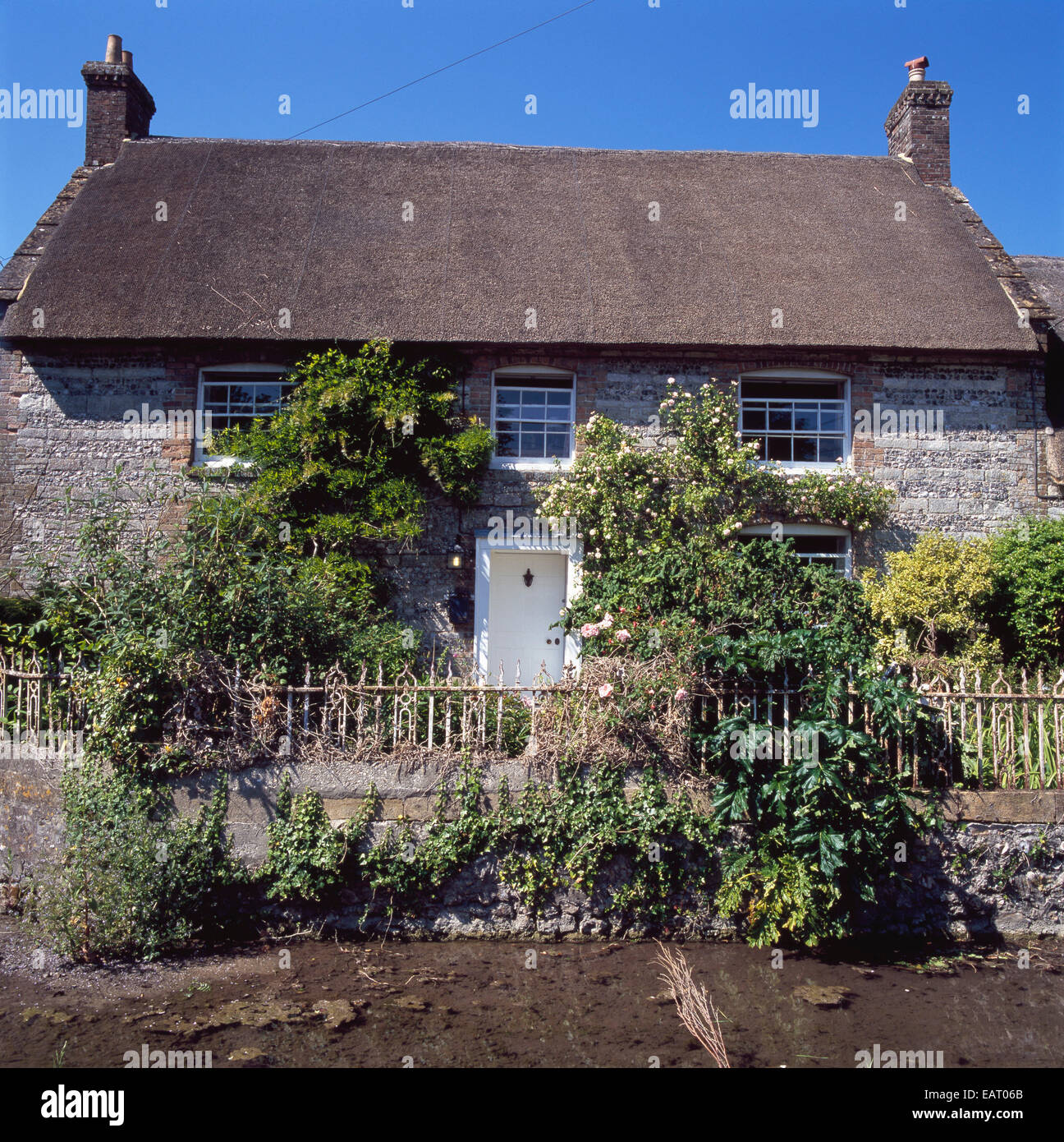The exterior of a traditional country house with thatched roof and a ...