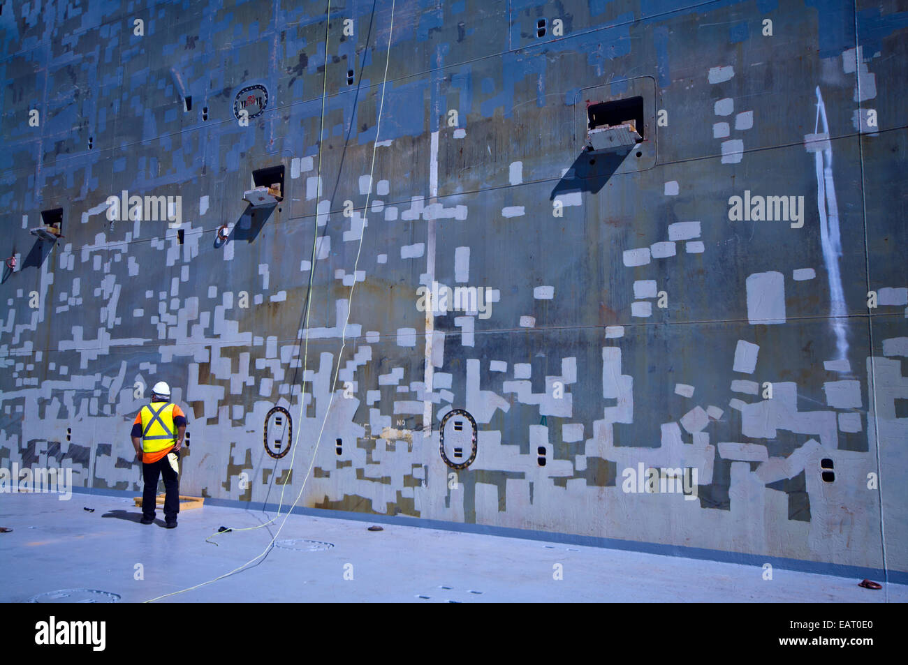 A stevedore inspects a ships cargo hold for steel corrosion Stock Photo ...