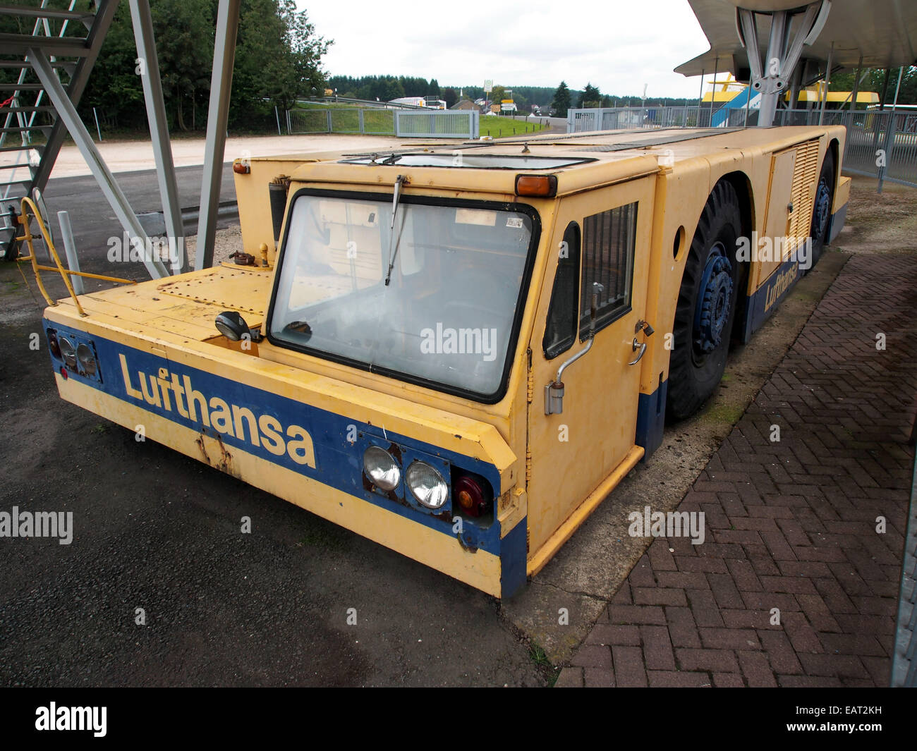 A Lufthansa pushback tractor is shown in action at an airport. These ...