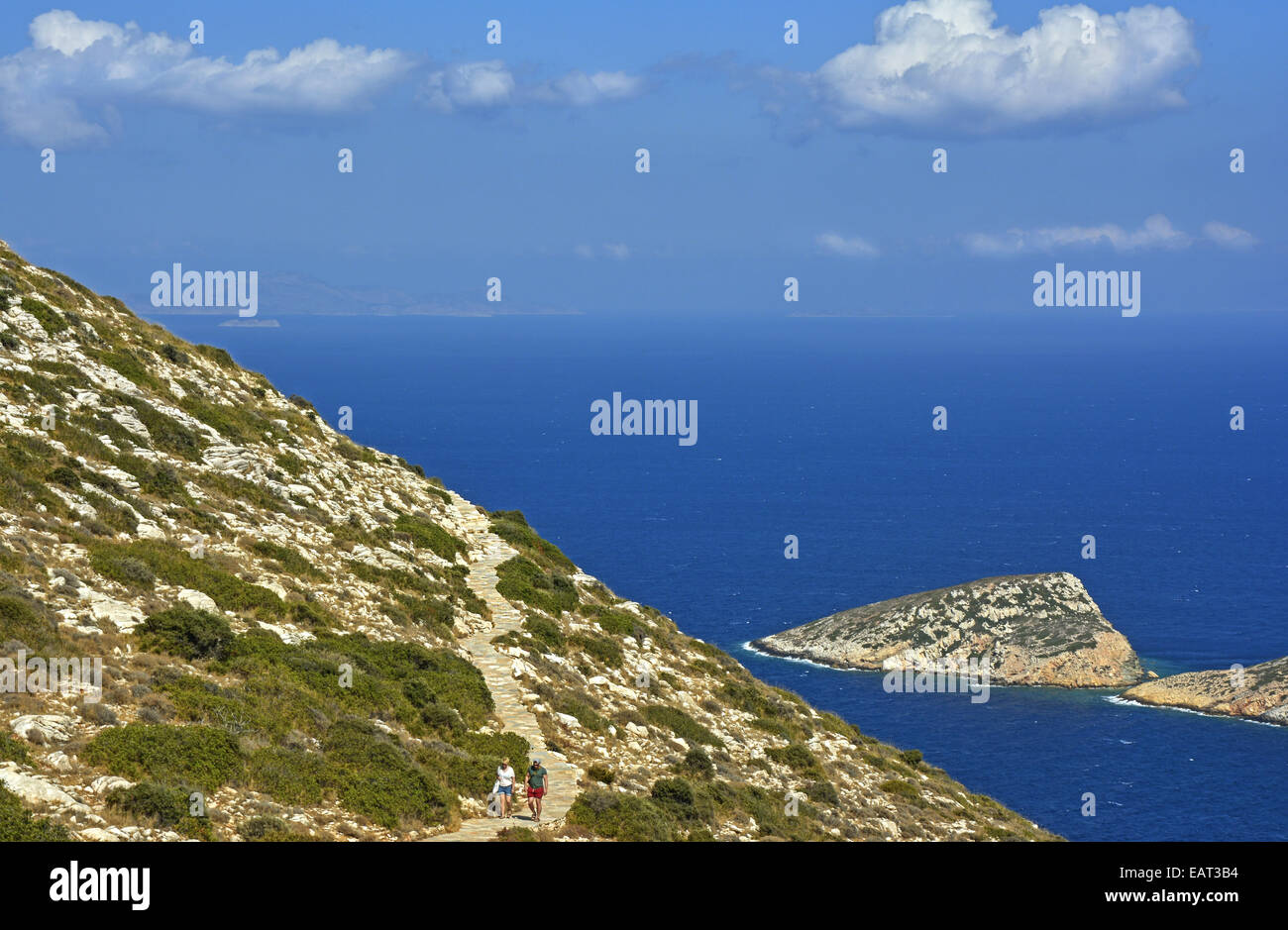 Tourists walking on the stone paved path leading to the fortified ...