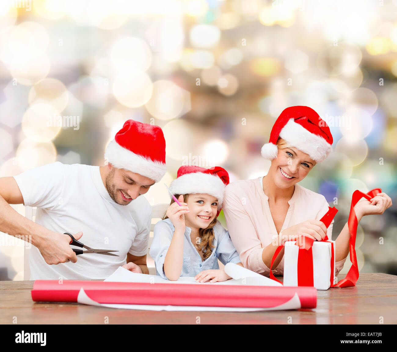 happy family in santa helper hats packing gift Stock Photo - Alamy