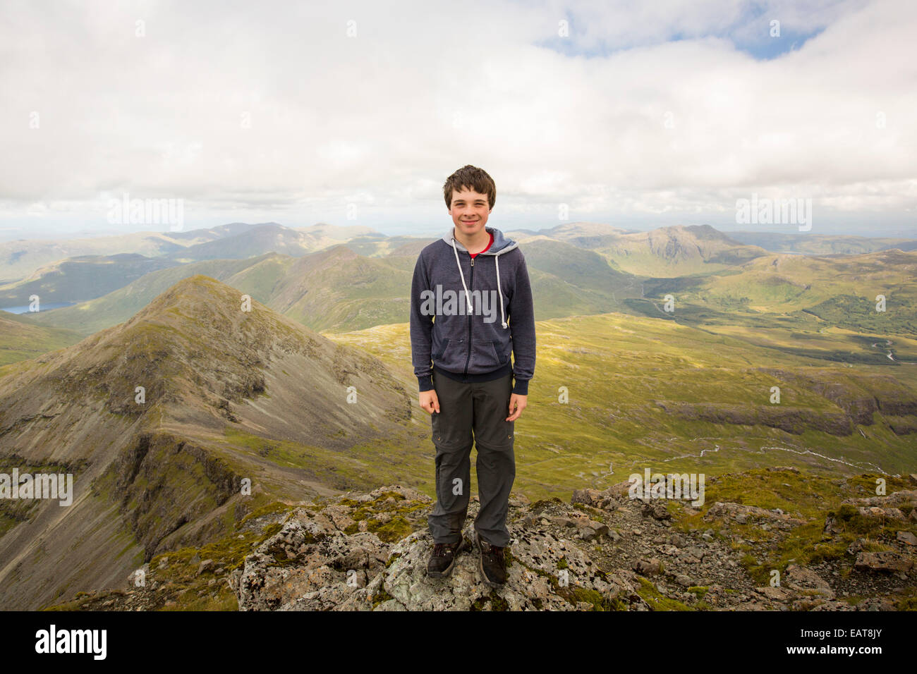 A teenage boy on the summit of Ben More, a Munro on the Isle of Mull ...