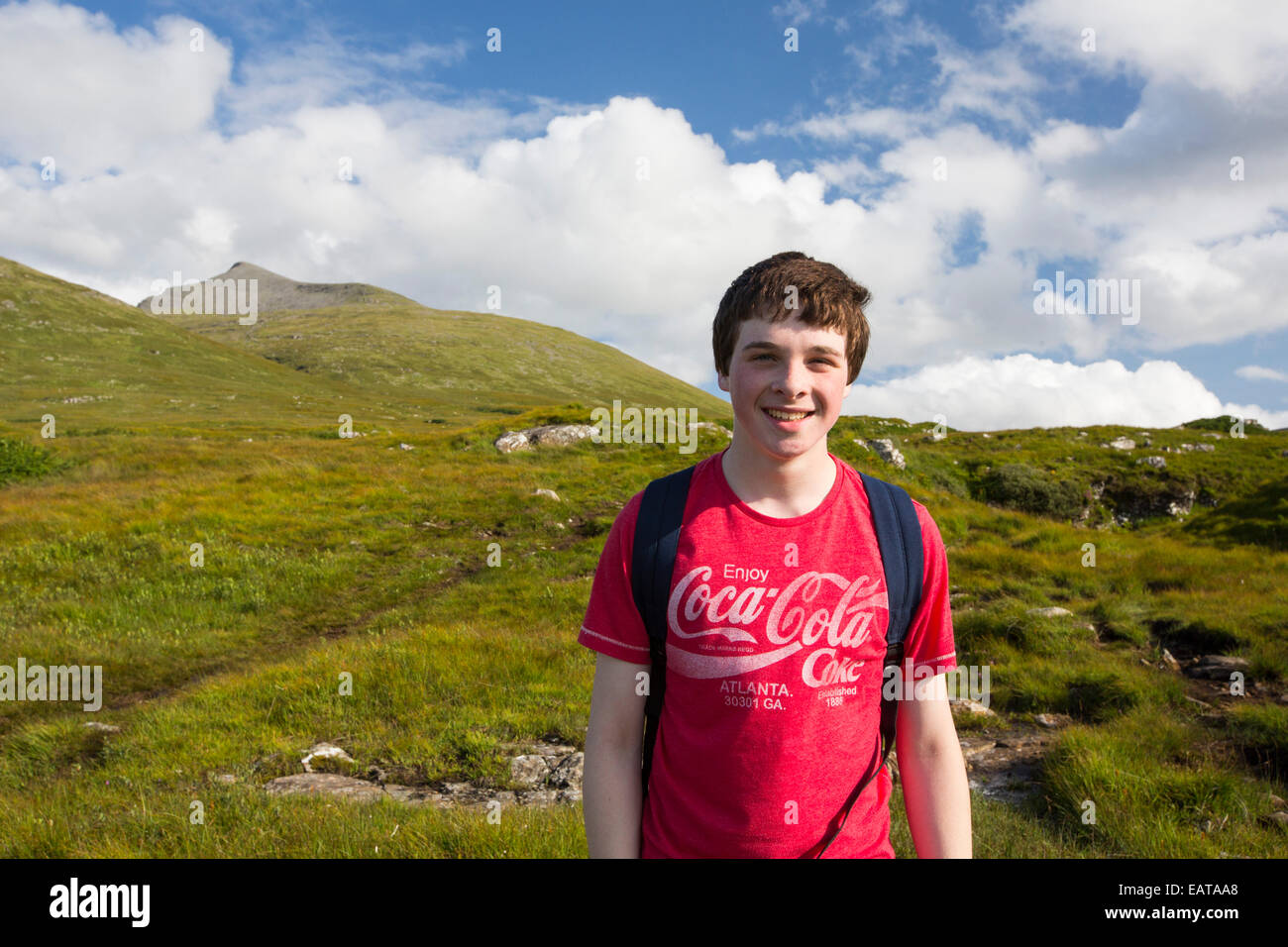 A teenage boy climbing Ben More, a Munro on the Isle of Mull, Scotland ...