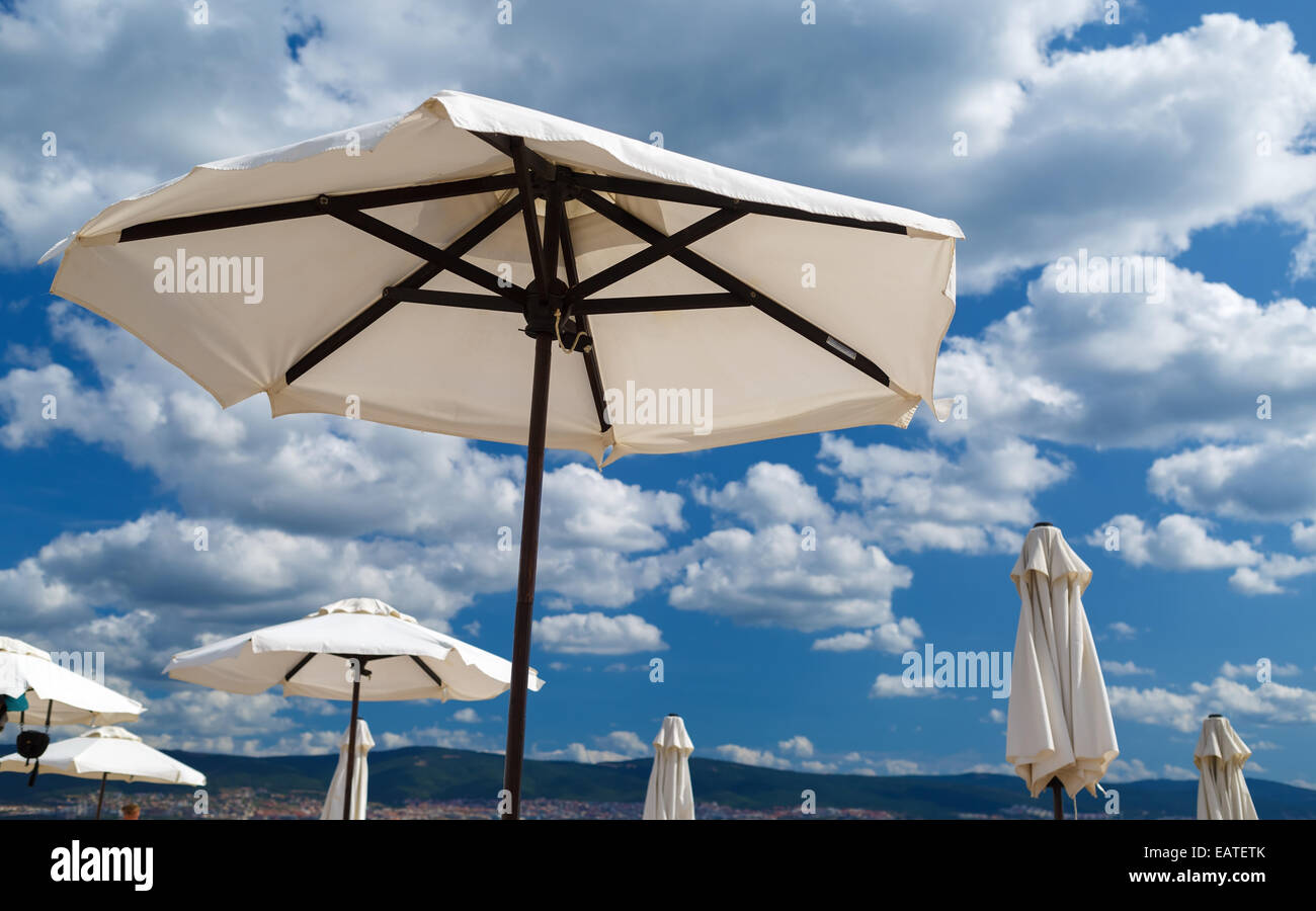 White beach umbrellas on a background of sea and sky. Shallow depth of ...