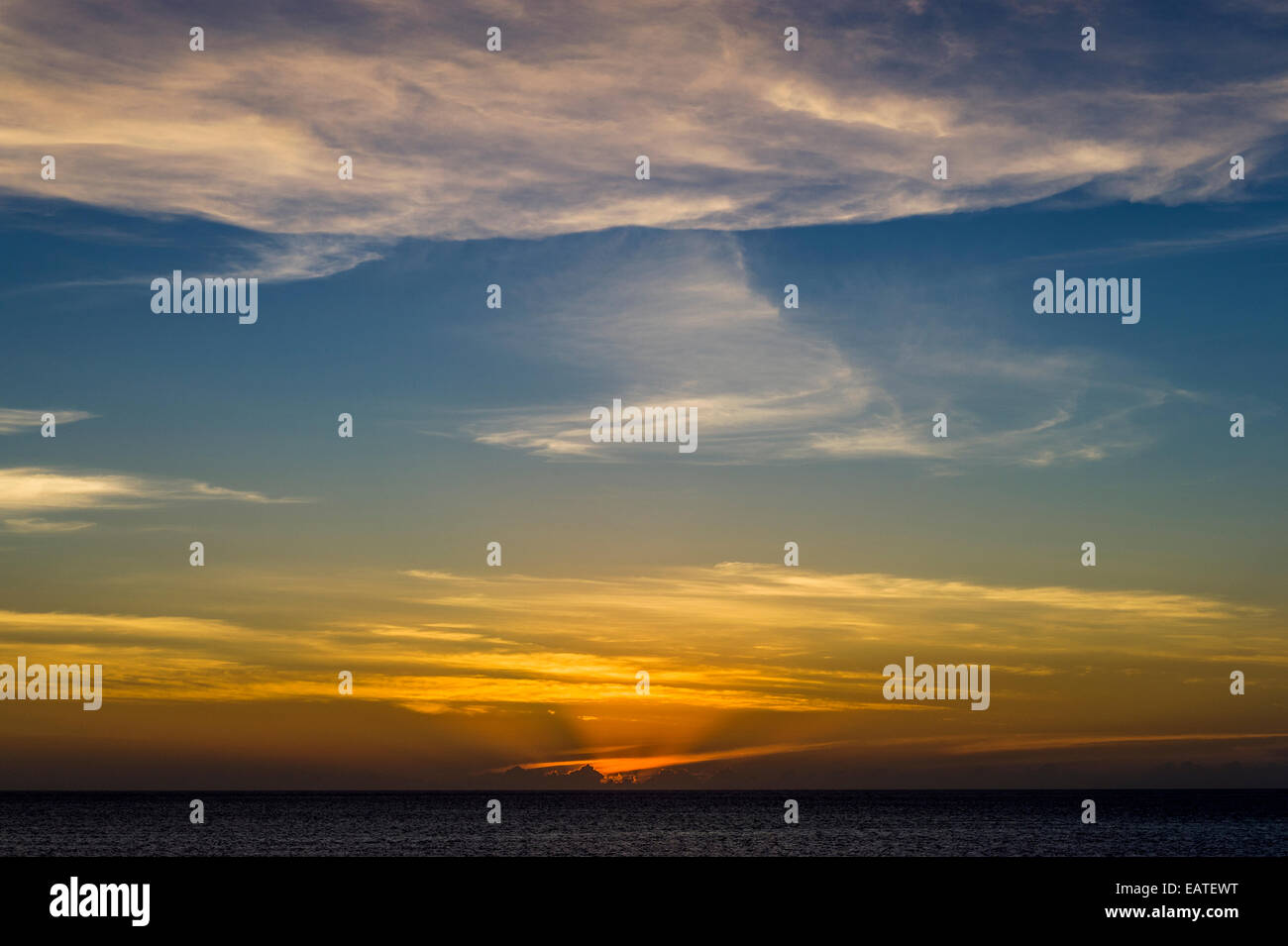 Sunset afterglow and pastel clouds over a calm tropical ocean Stock ...