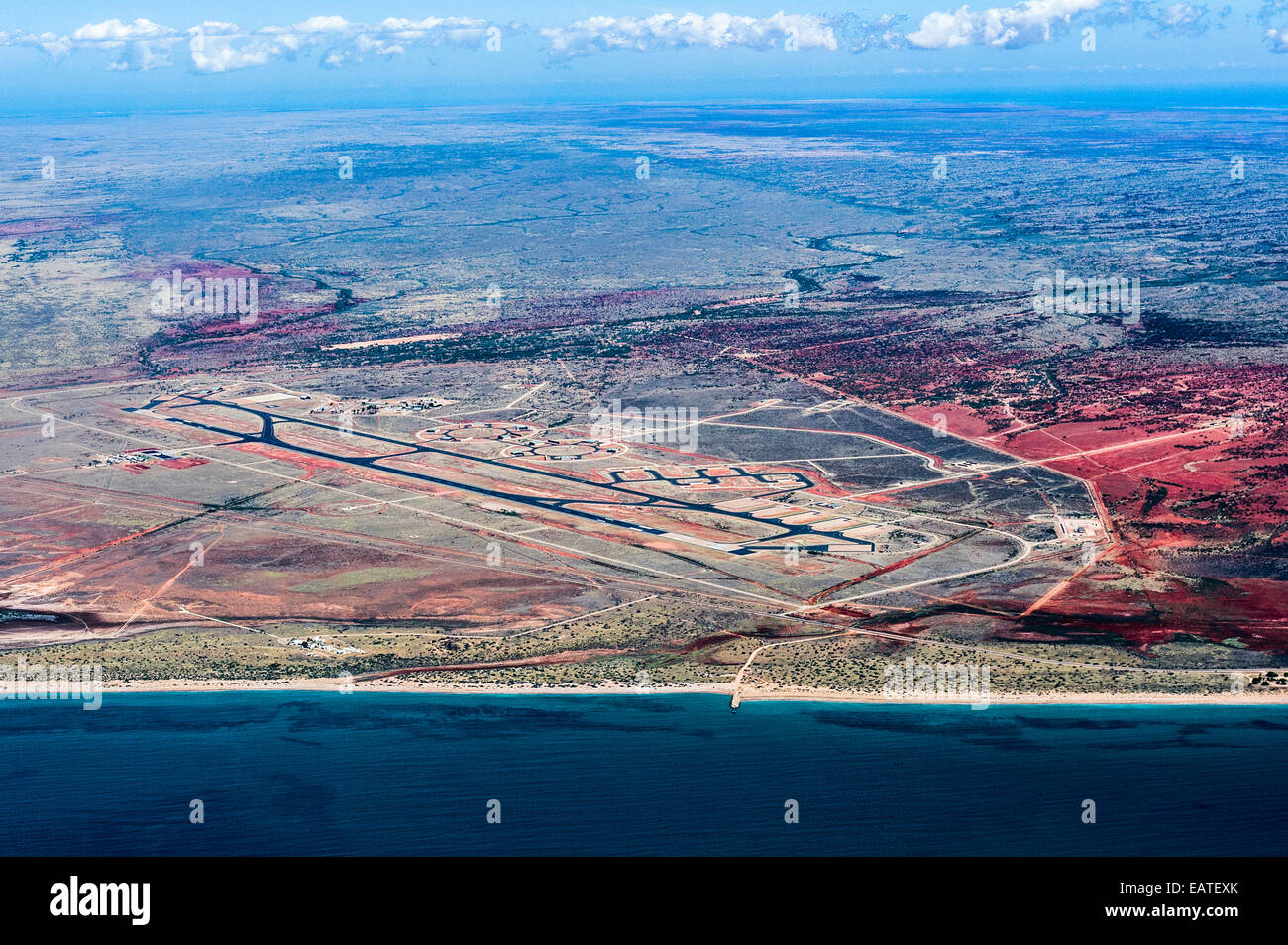 An aerial view of an airport and runway tarmac in a coastal desert ...