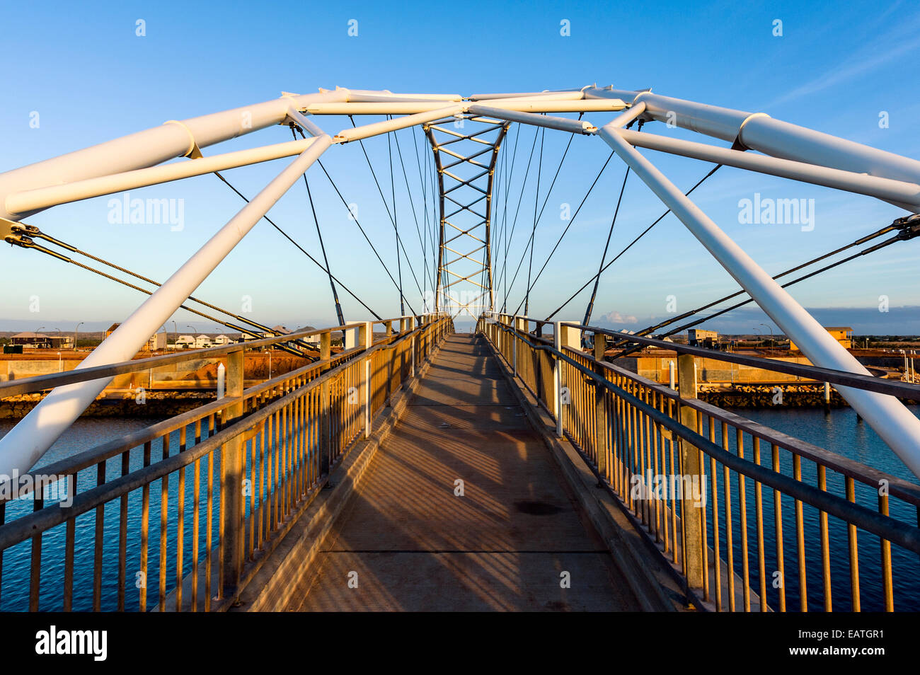 Steel girders of a residential foot bridge arching over a tidal canal ...