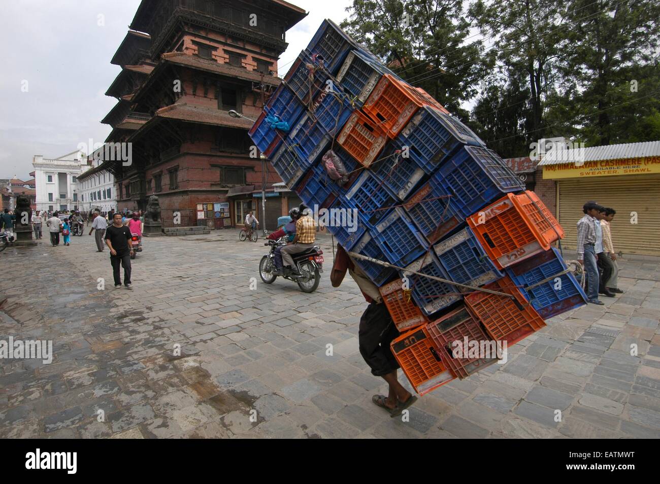 A man carrying a heavy weight with his back Stock Photo - Alamy