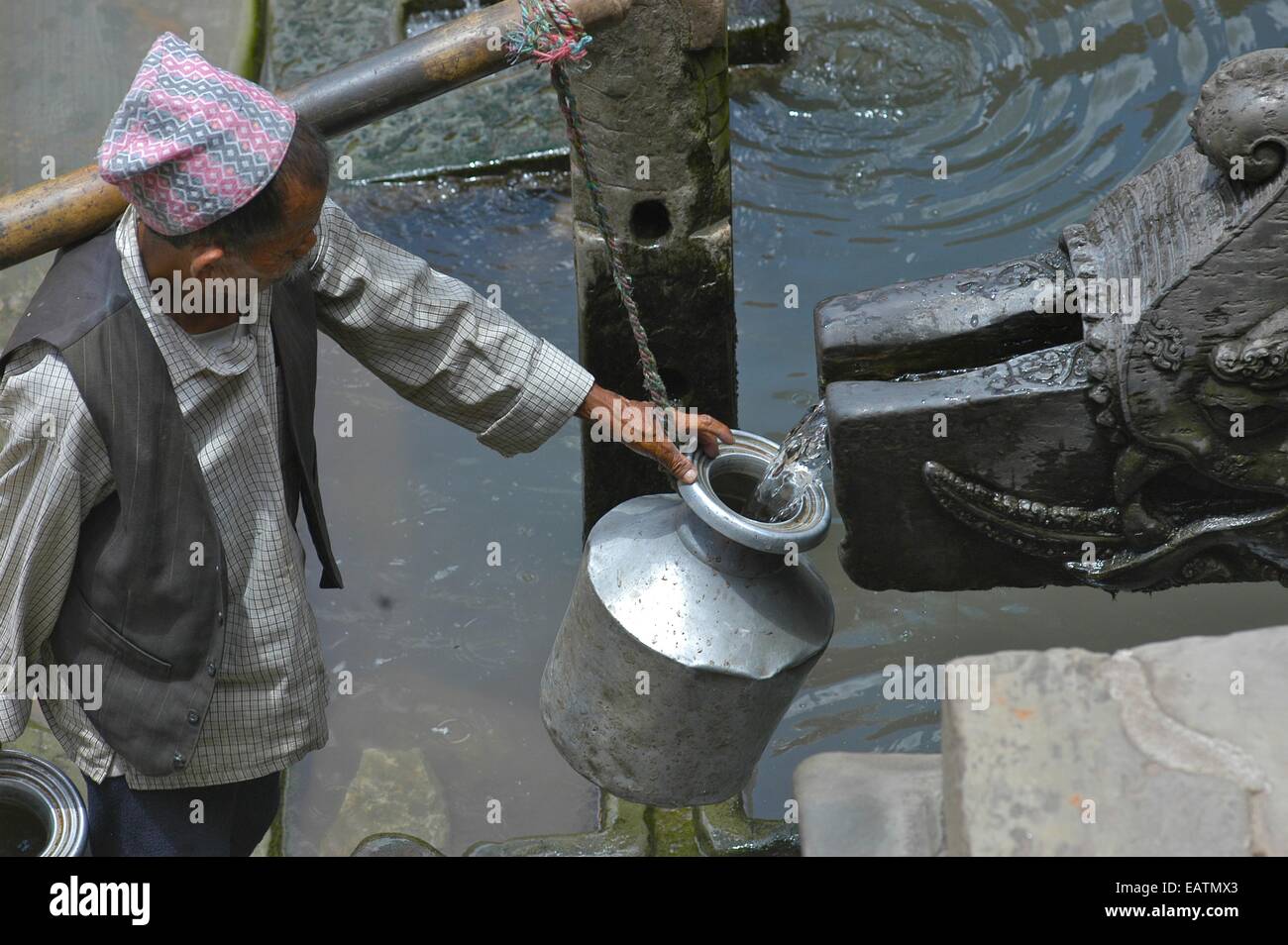 A man collecting water from a public fountain Stock Photo - Alamy