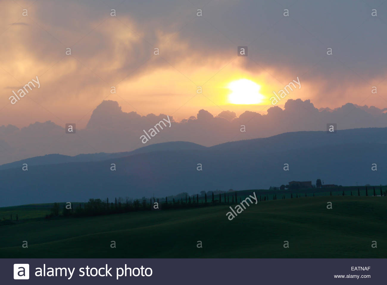 A pasture and farm with a sunset behind Stock Photo - Alamy