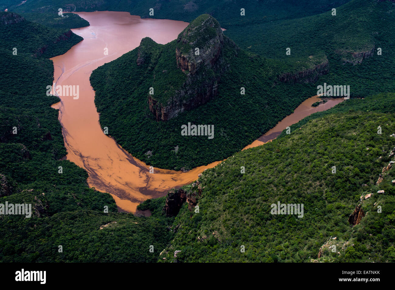 A flooded river full of soil and silt carves its way through a gorge ...