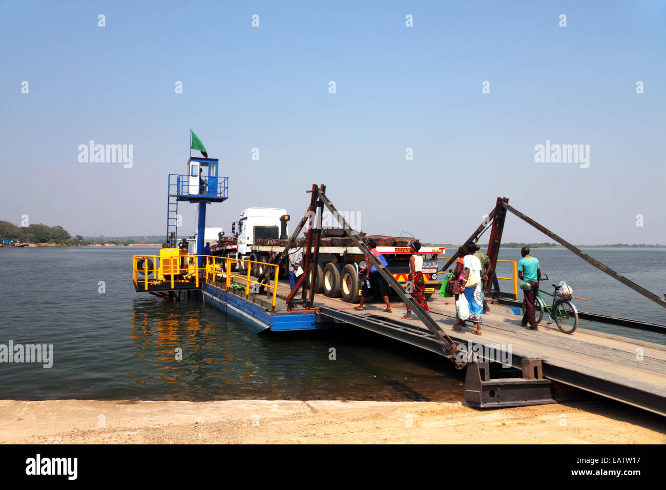 An African vehicular ferry with trucks, bicycles and pedestrians ...
