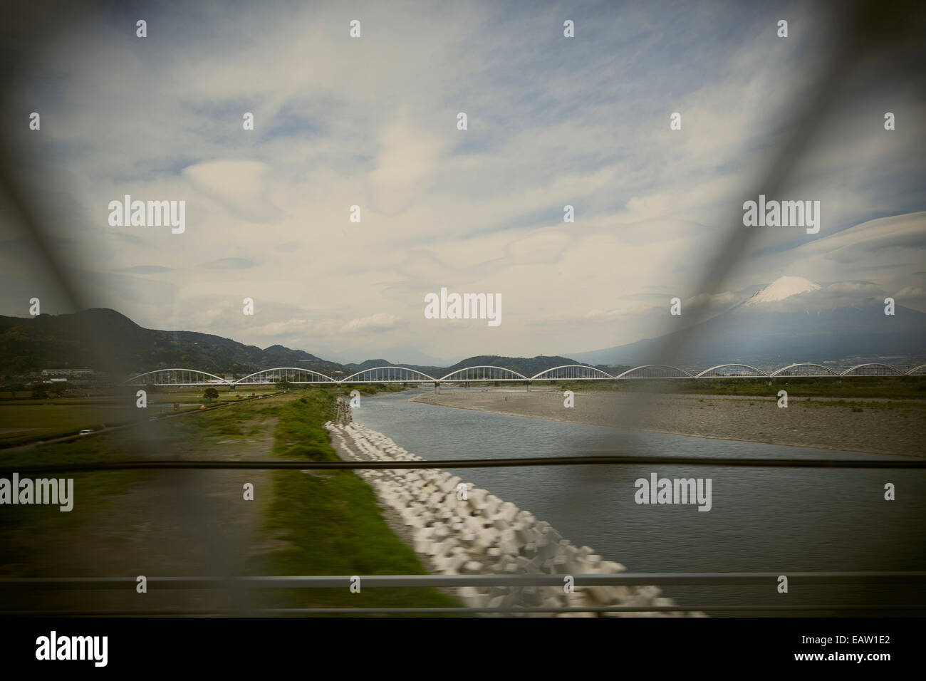 A picturesque rural view of a hill and a distant bridge over a canal ...