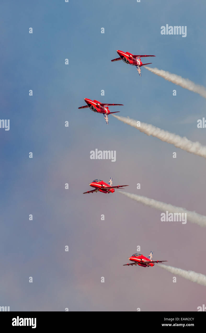 Four RAF Red Arrows perform an acrobatic maneuver in a mirror image ...