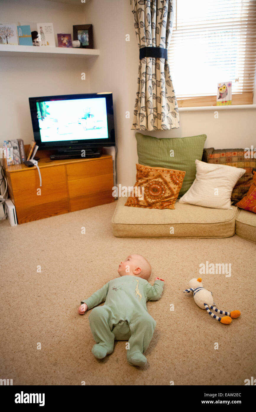 Baby on floor watching television Stock Photo - Alamy