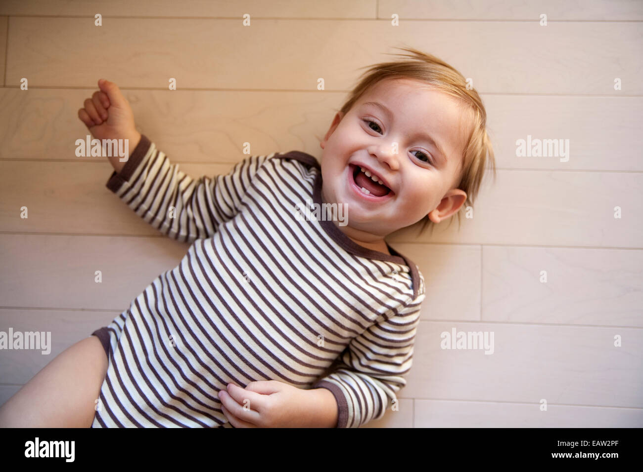 Baby laughing on floor Stock Photo - Alamy